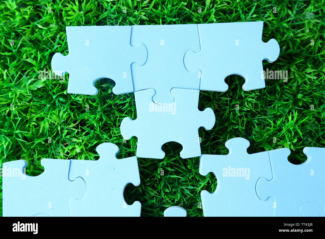 Puzzle pieces on green grass background. Green space concept Stock ...