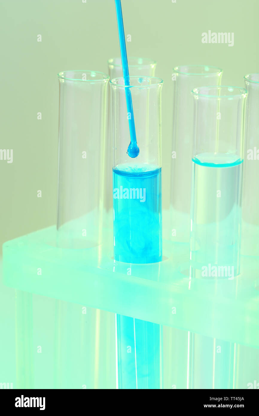 Test-tubes with blue liquid and stick on blue background Stock Photo ...