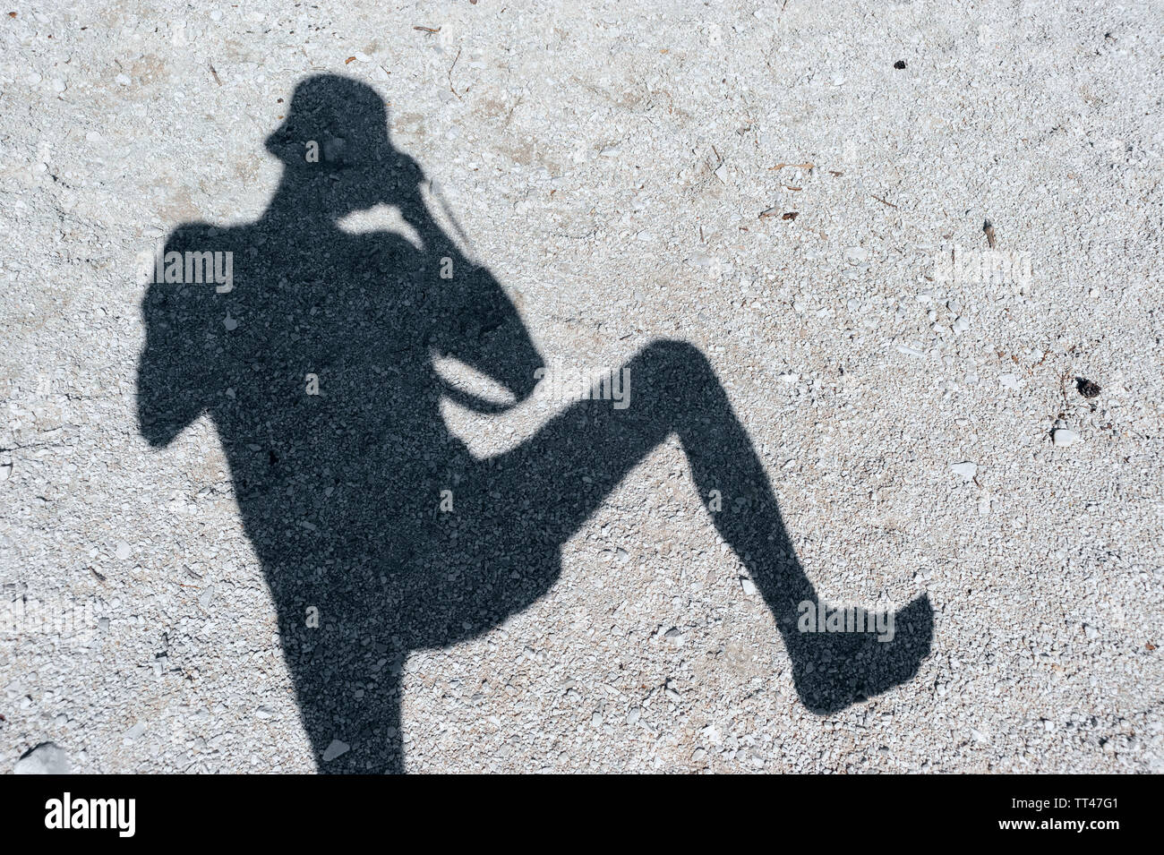 Self-portrait of photographer with camera in hands casting shadow on ...