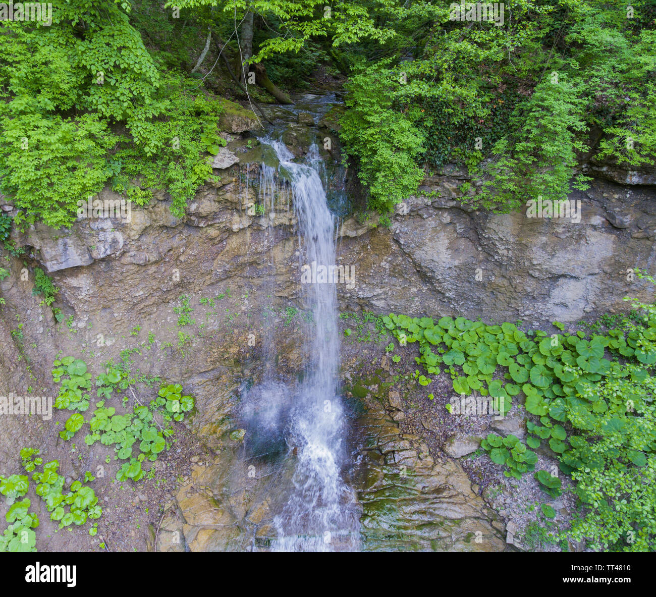 Long the flow of the waterfall cascading from the cliff. Aerial view ...
