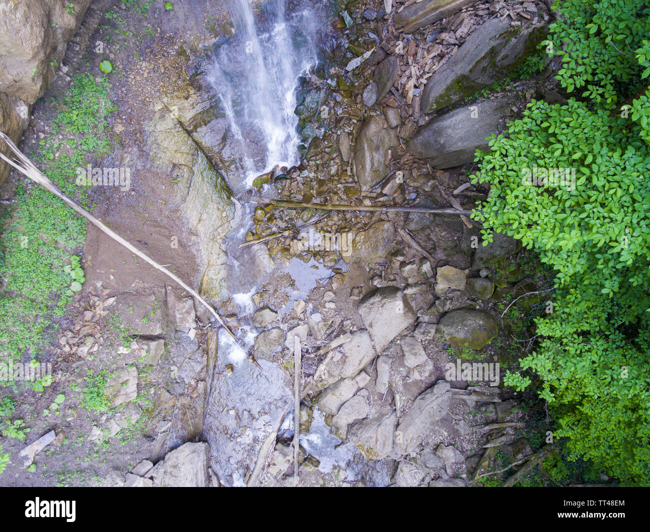 Stream bed with stones and logs that brought a waterfall. Aerial view ...