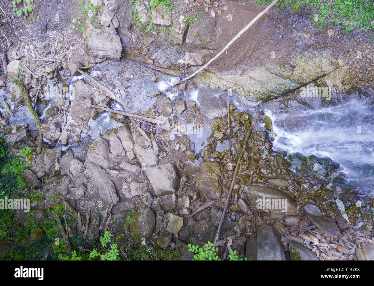 Stream bed with stones and logs that brought a waterfall. Aerial view ...