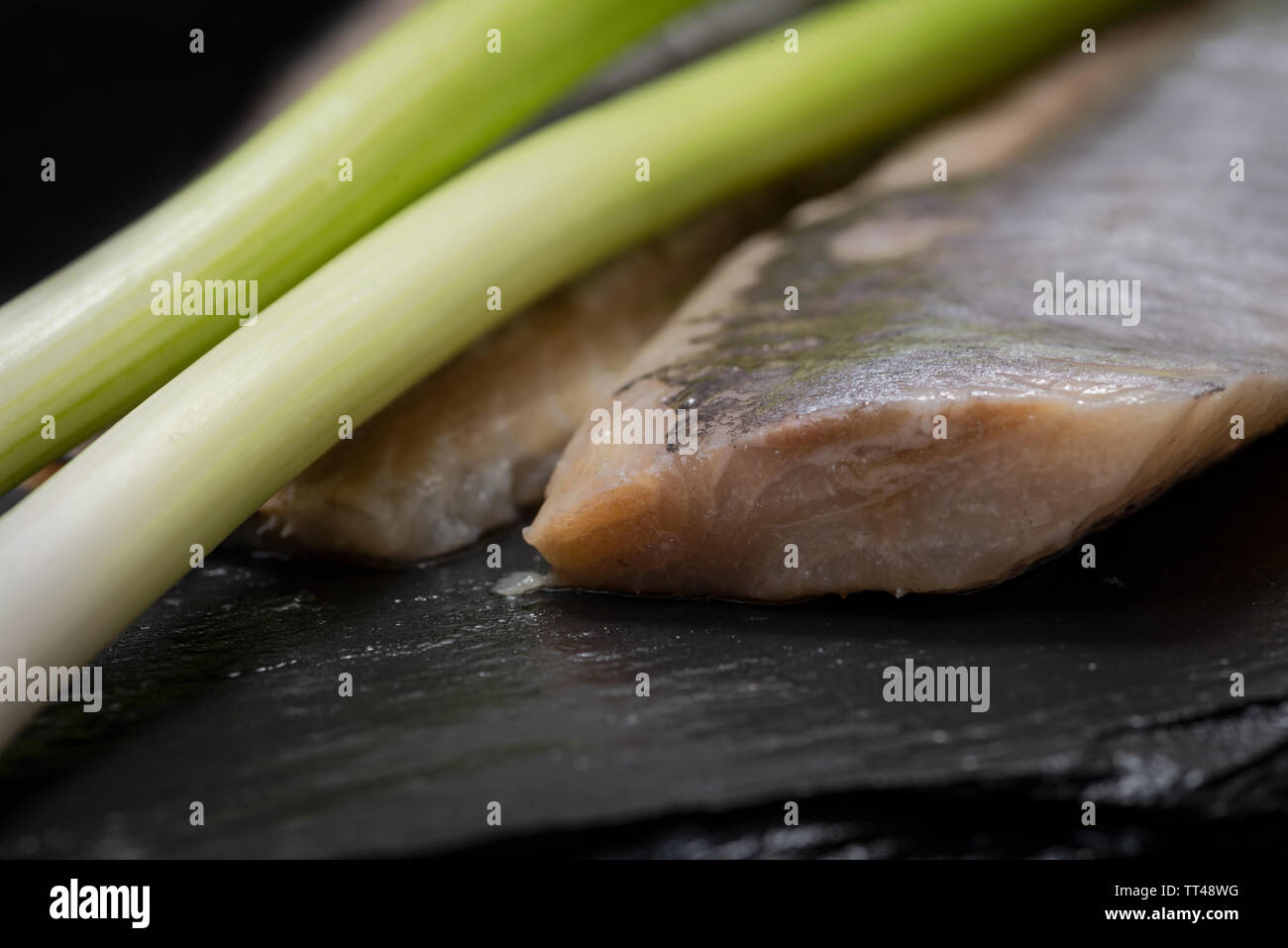 Salt Herring Fillets and Organic Green Onion Scallions arranged on ...