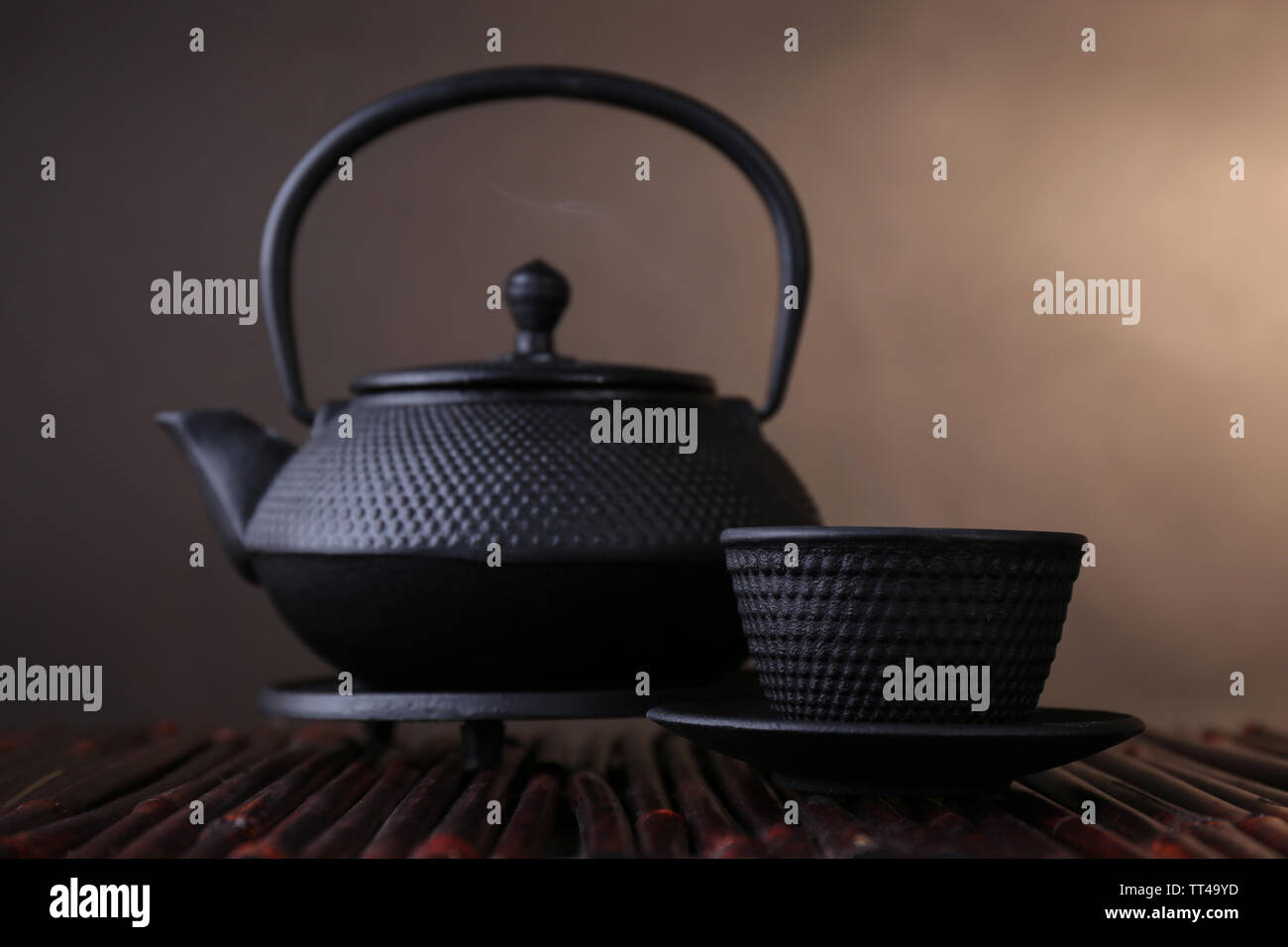 Chinese traditional teapot on bamboo mat, on dark color background ...