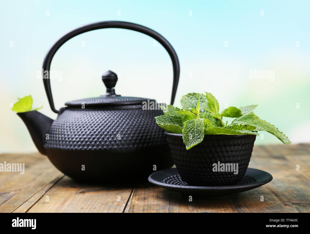 Chinese traditional teapot with fresh mint leaves on wooden table, on ...