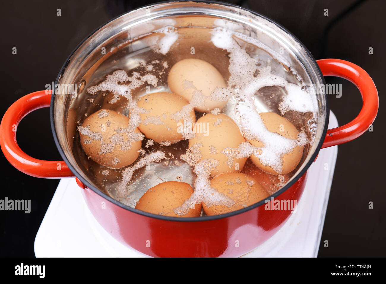 Eggs in boiling water in pan on electric hob Stock Photo - Alamy