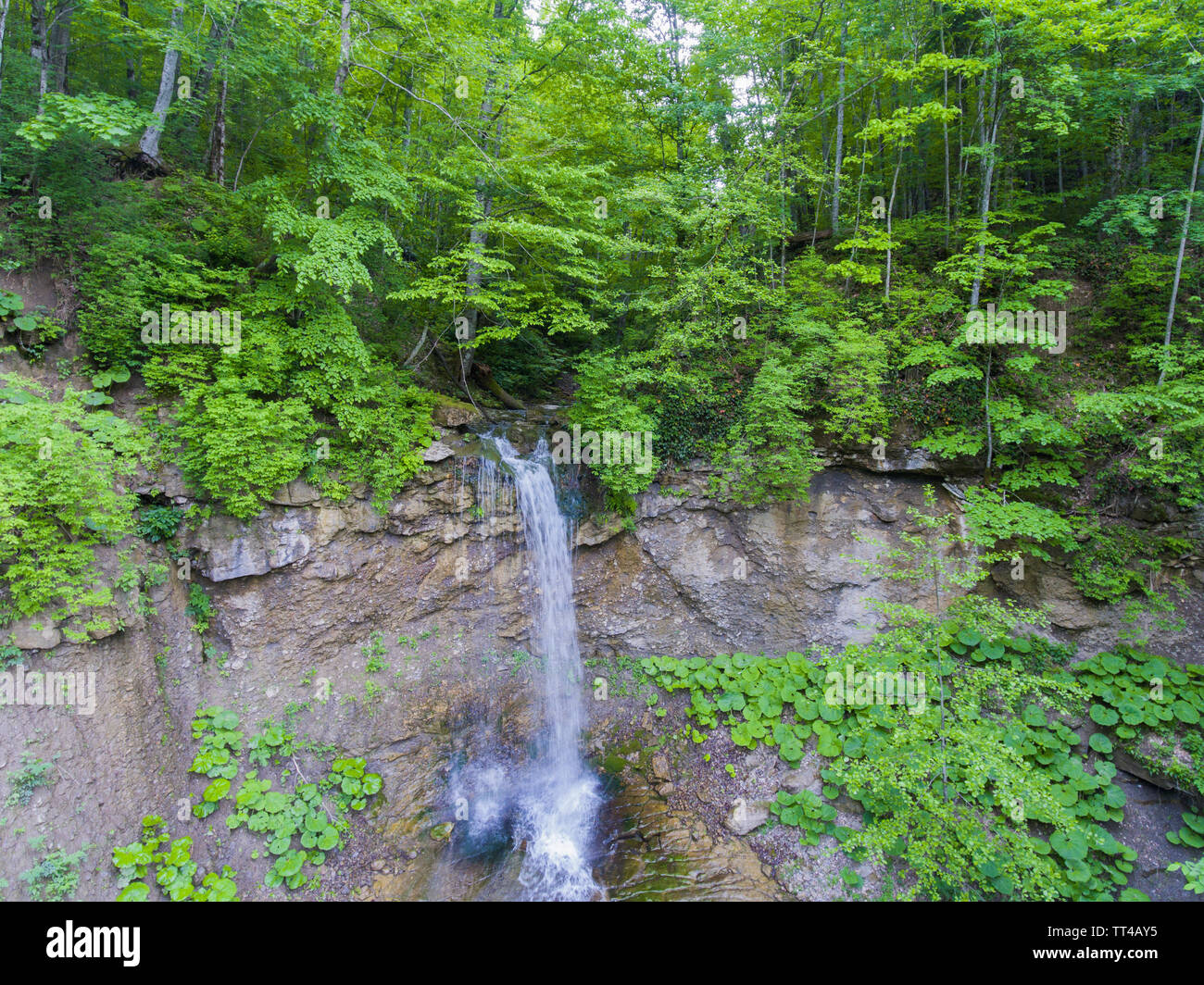 Long the flow of the waterfall cascading from the cliff. Aerial view ...