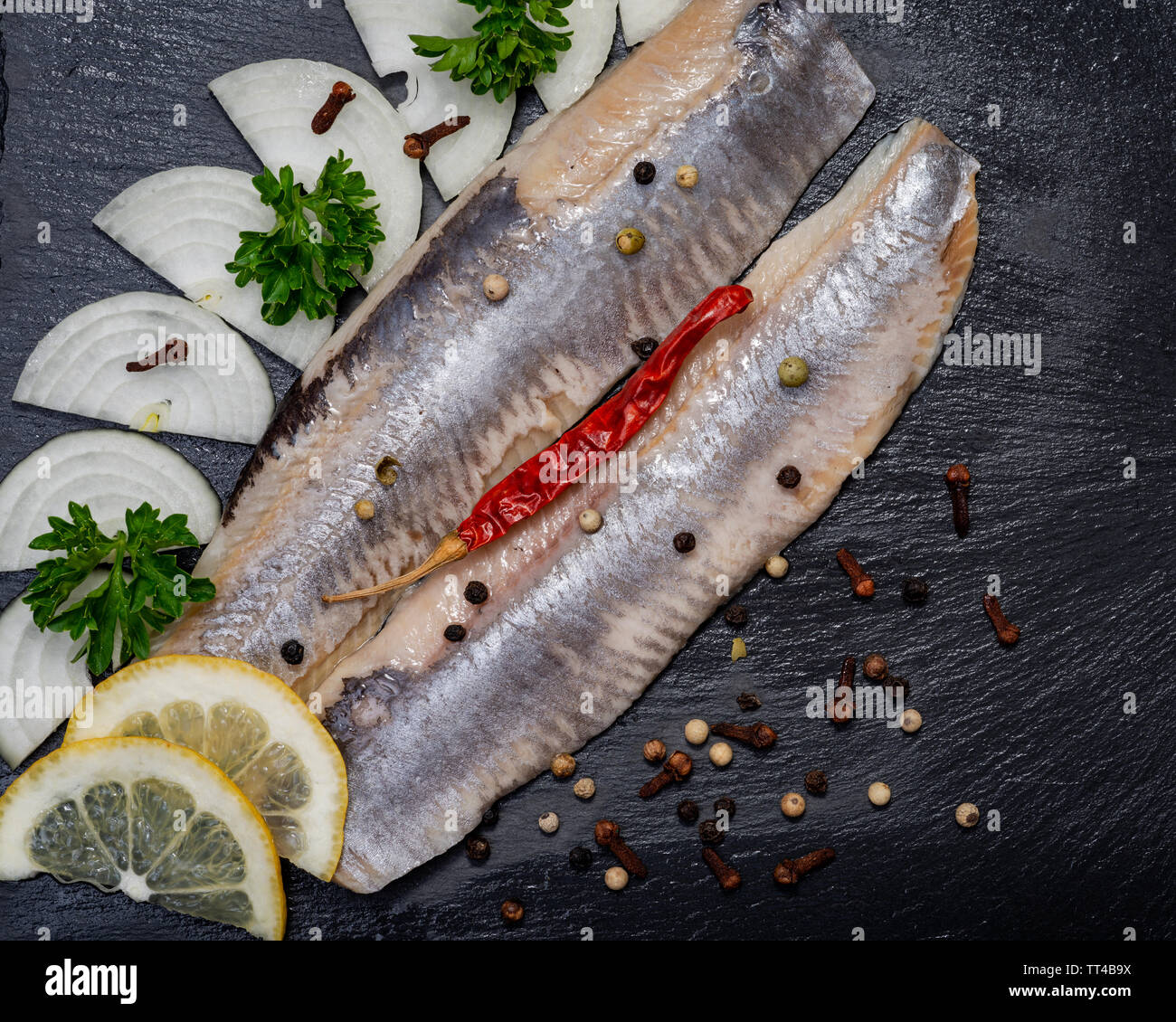 Salted Herring Fillets garnished with Yellow Onion, Lemon, Fresh ...