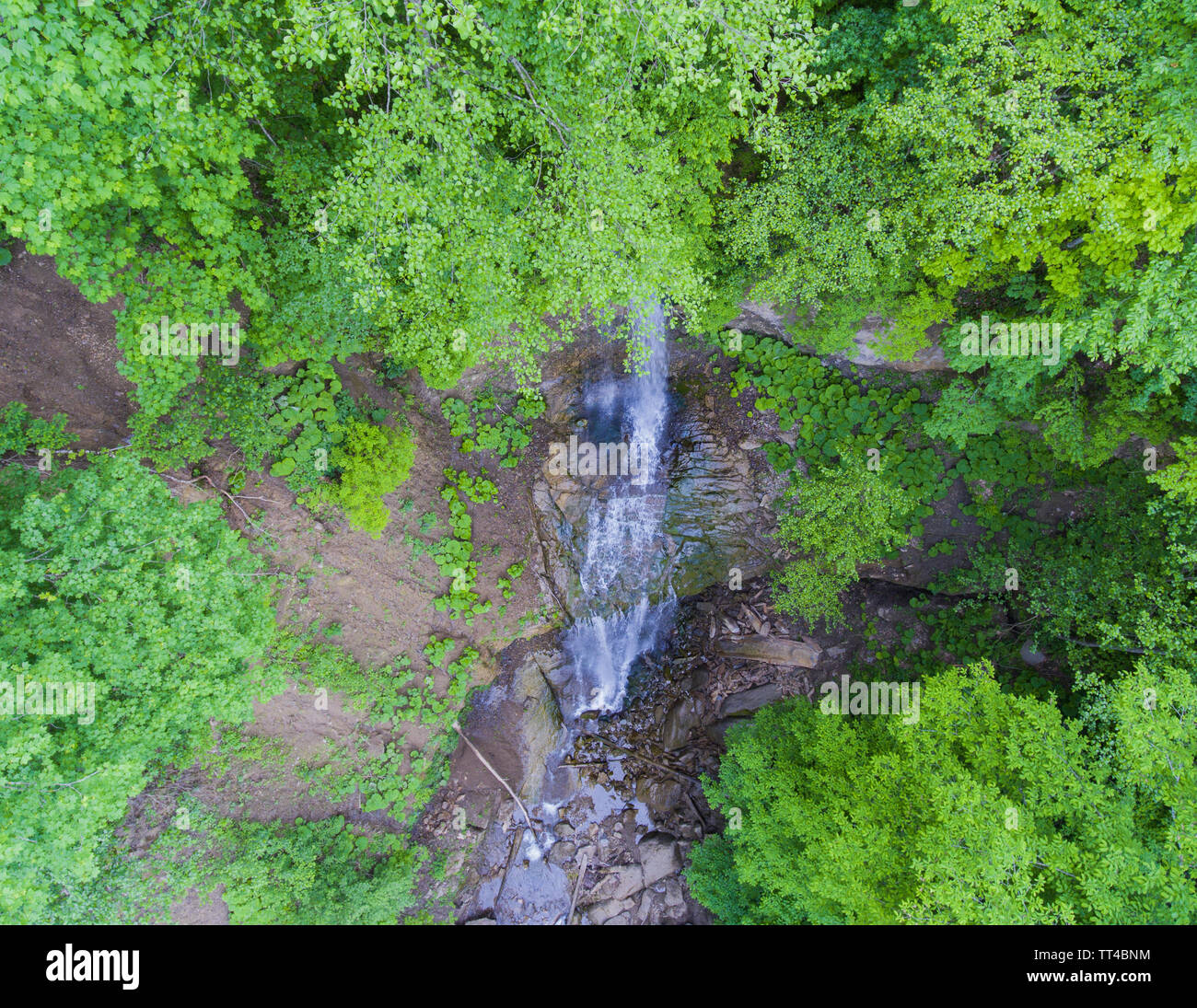 Long the flow of the waterfall cascading from the cliff. Aerial view ...
