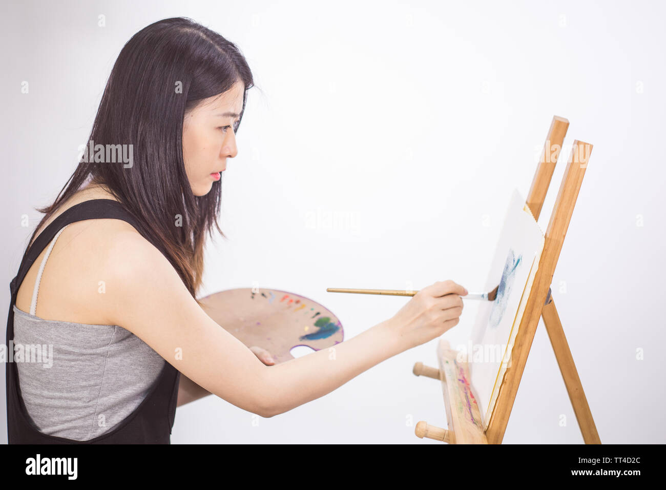 Artist painting oil painting on an easel Stock Photo - Alamy