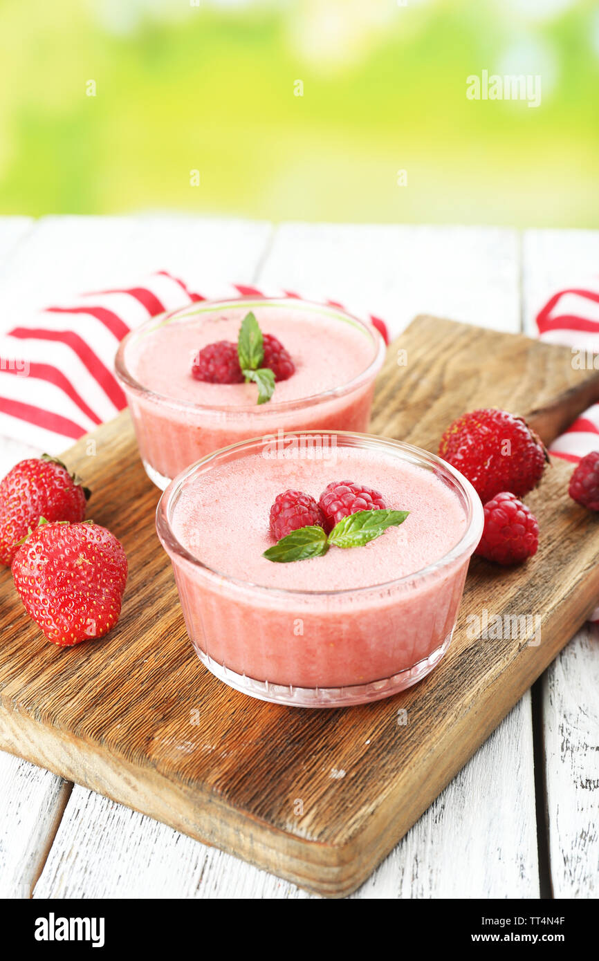 Delicious berry mousse in bowls on table on bright background Stock ...