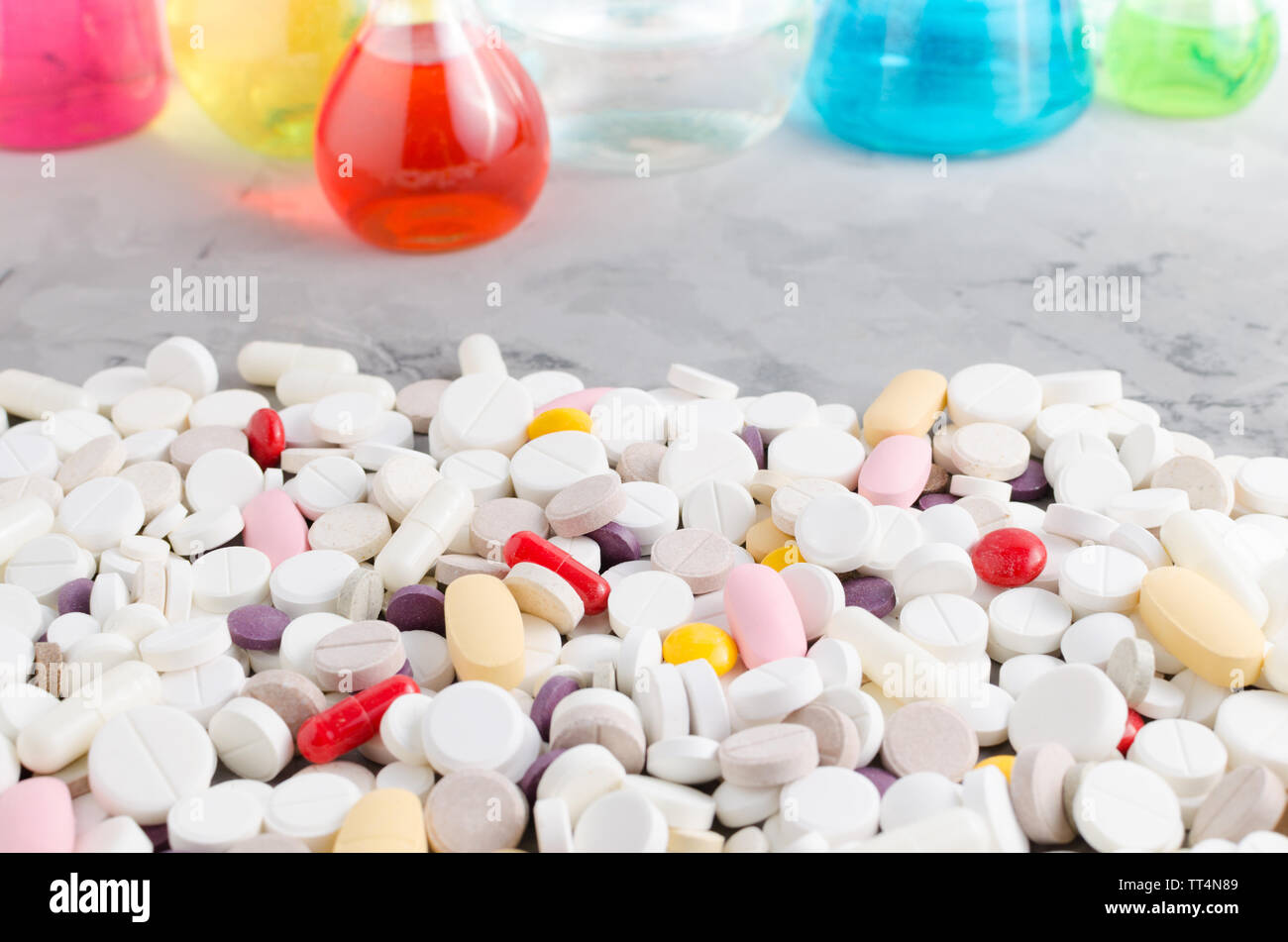 A large variety of medicinal pills on the background of vials and ...