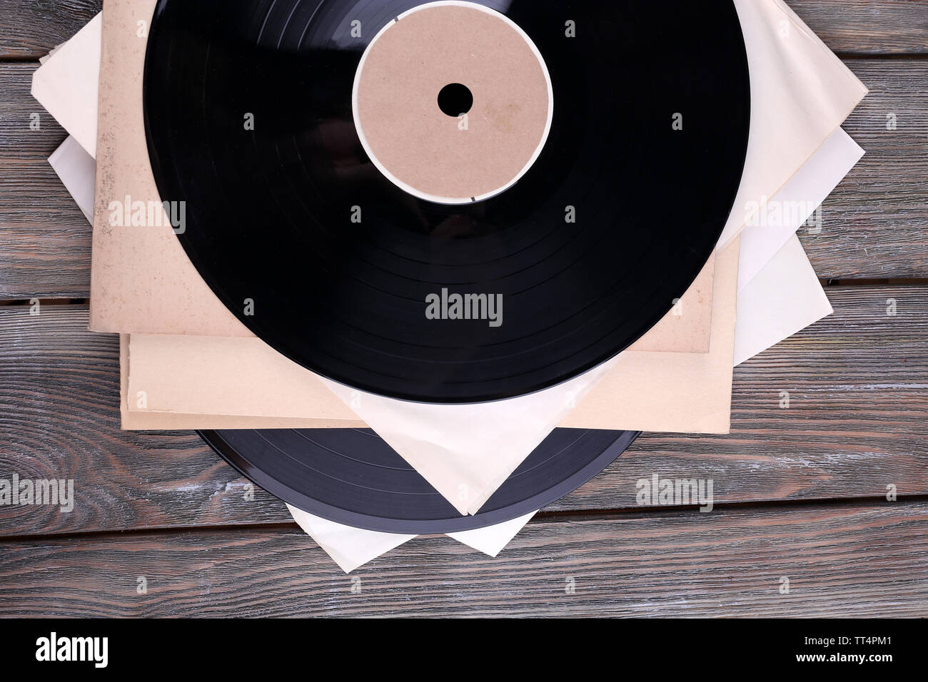 Vinyl records records and paper covers on wooden background Stock Photo ...
