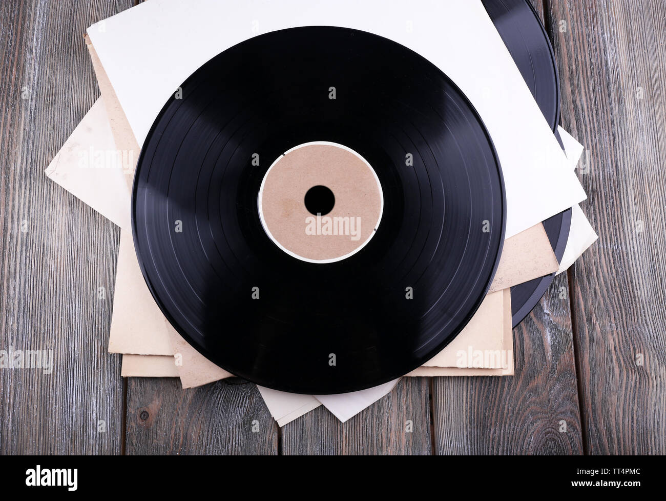 Vinyl records records and paper covers on wooden background Stock Photo ...