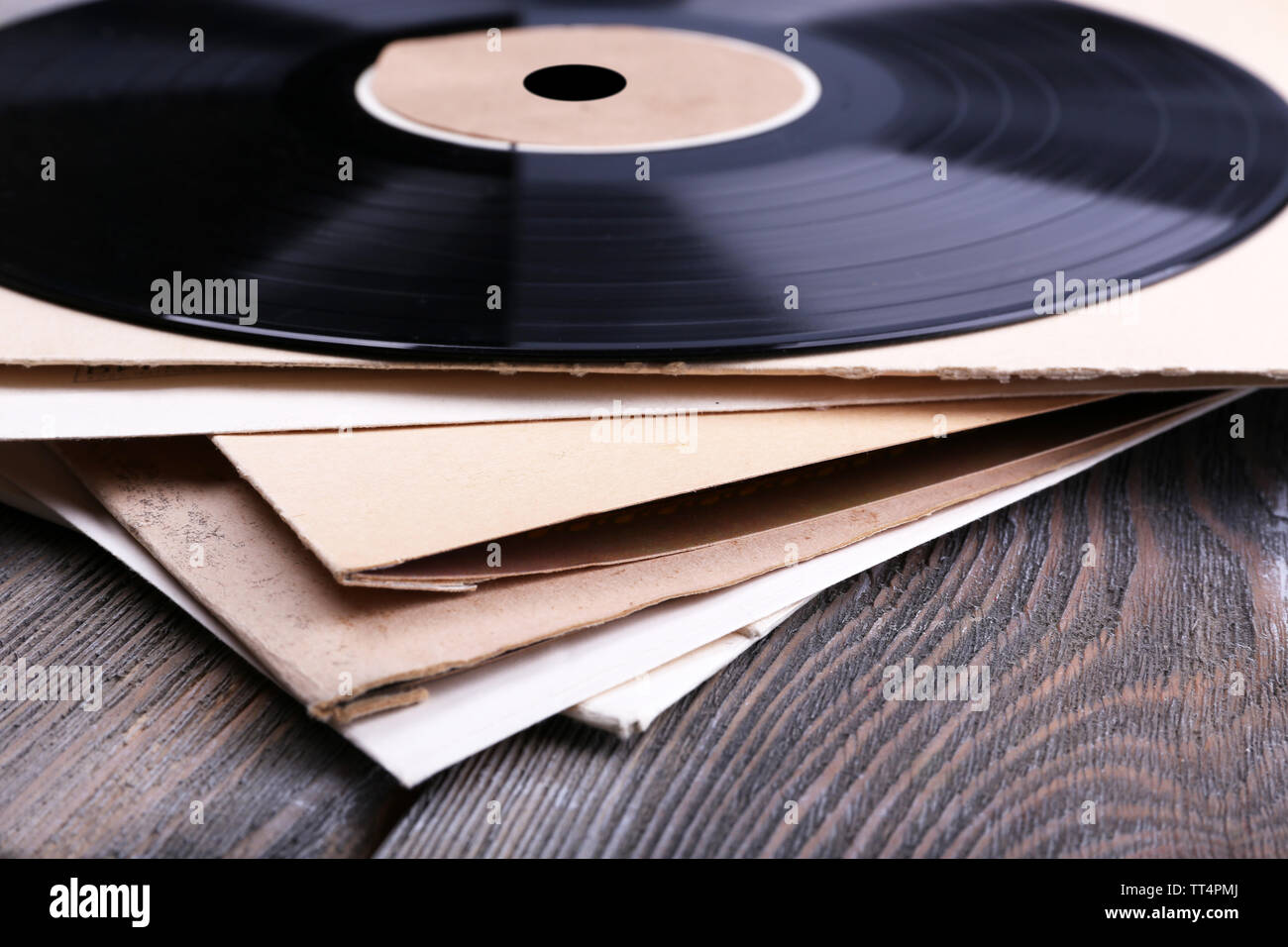 Vinyl records records and paper covers on wooden background Stock Photo ...