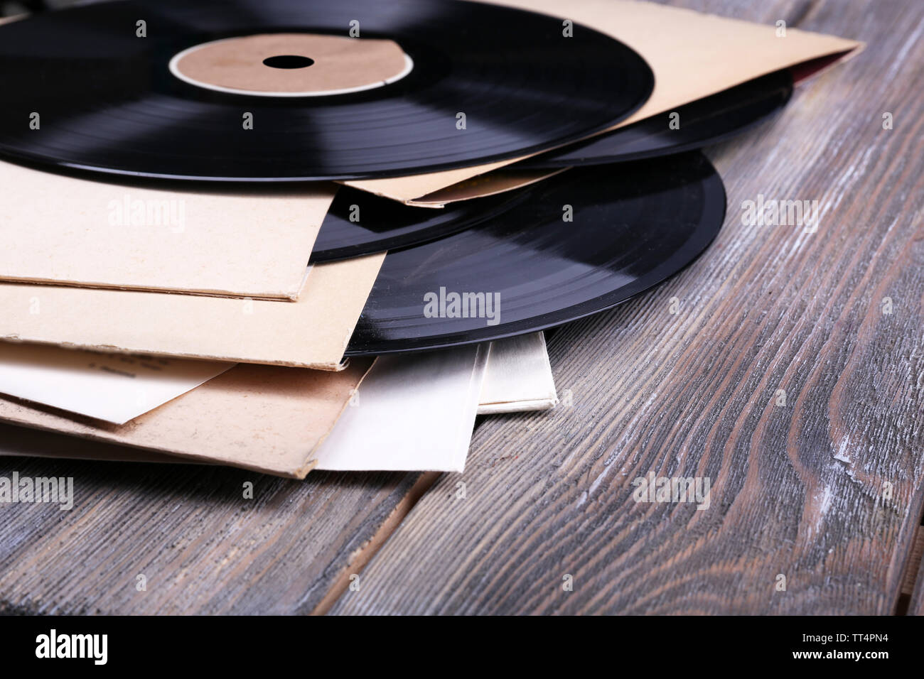 Vinyl records records and paper covers on wooden background Stock Photo ...
