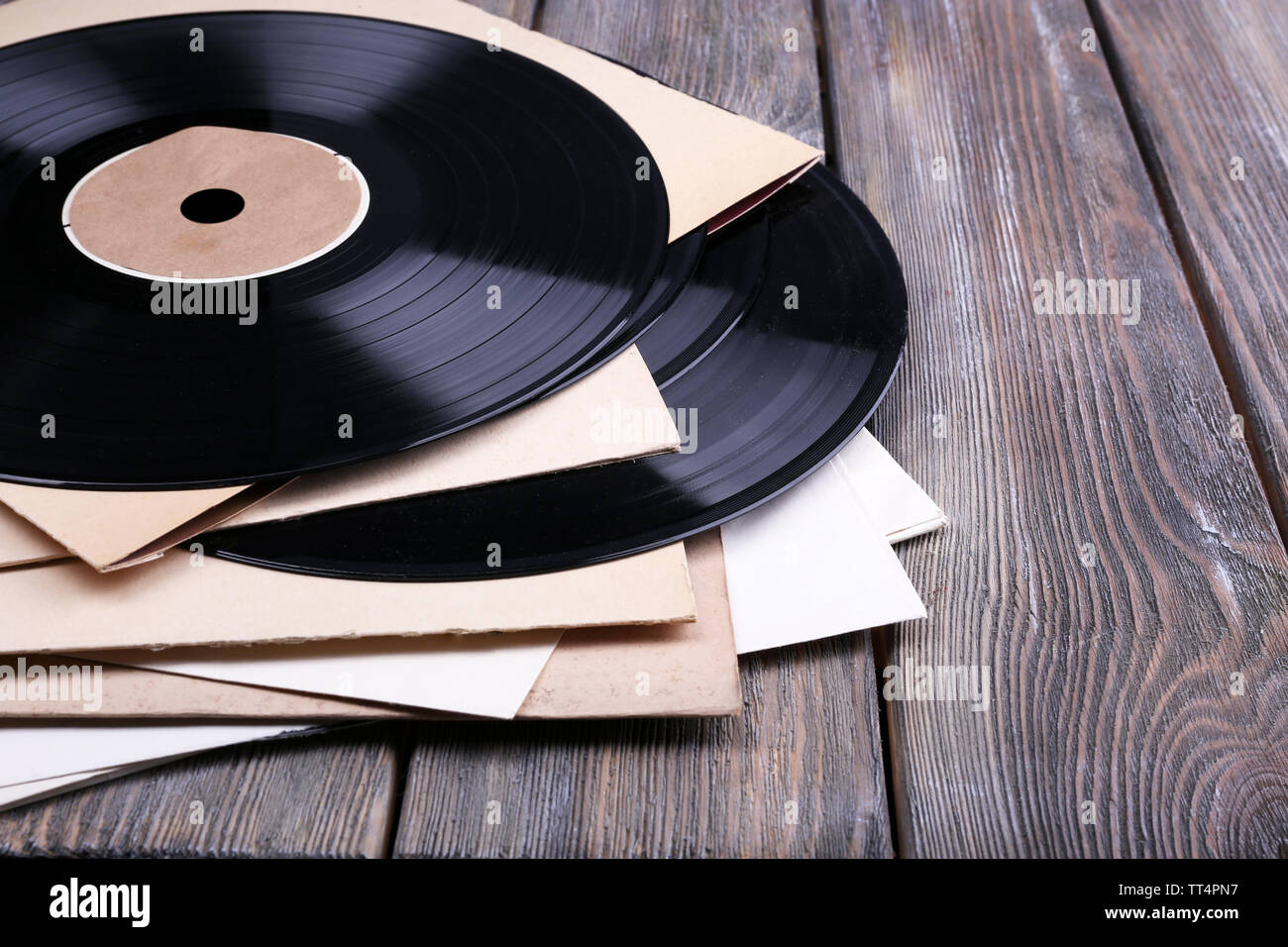 Vinyl records records and paper covers on wooden background Stock Photo ...