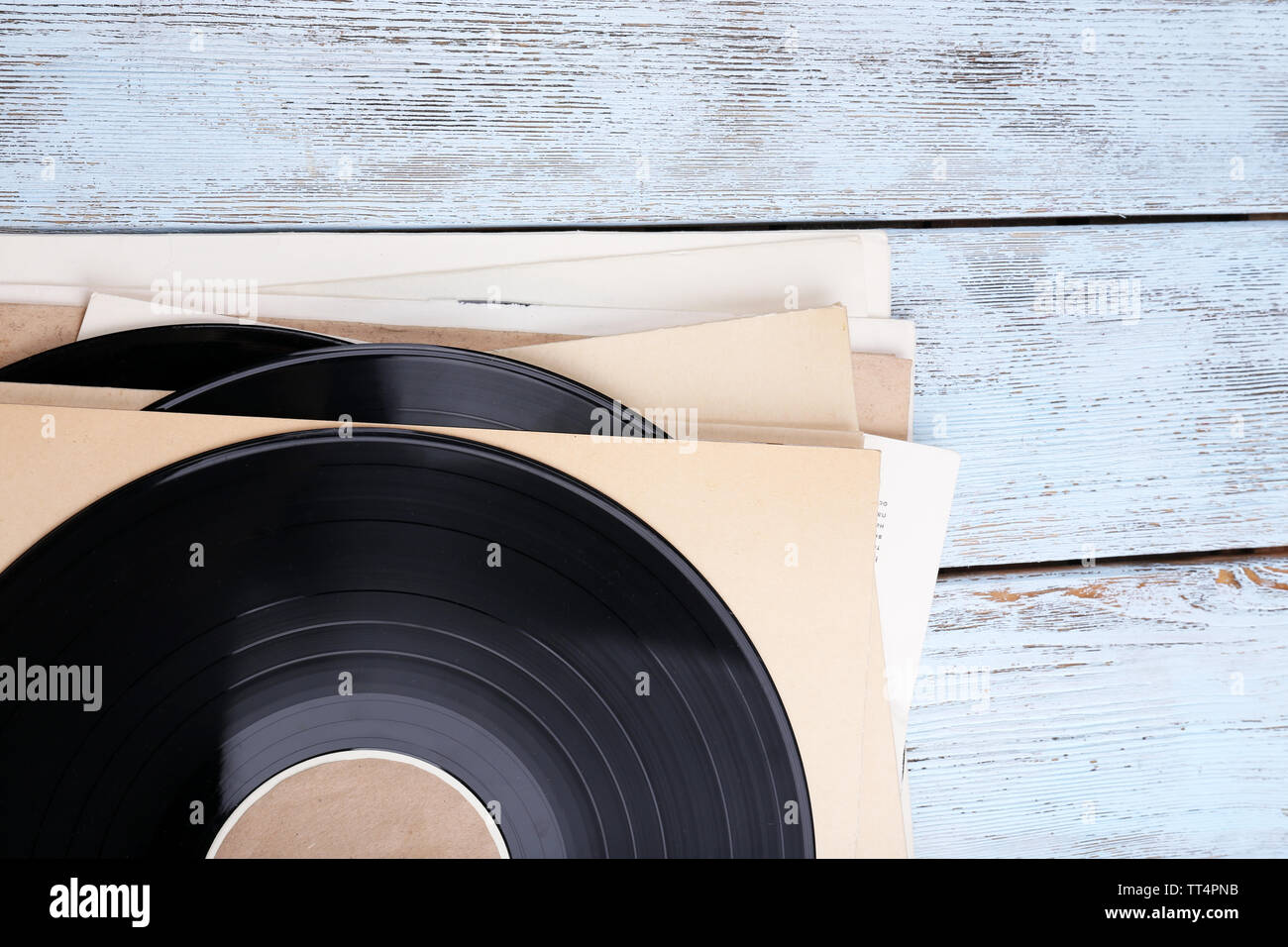 Vinyl records records and paper covers on wooden background Stock Photo ...