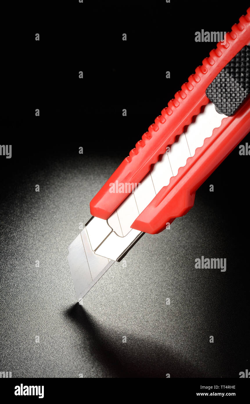 Utility knife, office knife on black grained surface Stock Photo - Alamy