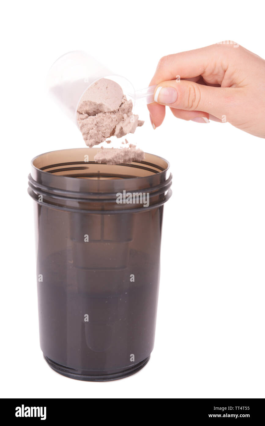 Female hand holding scoop with whey protein powder and plastic shaker ...