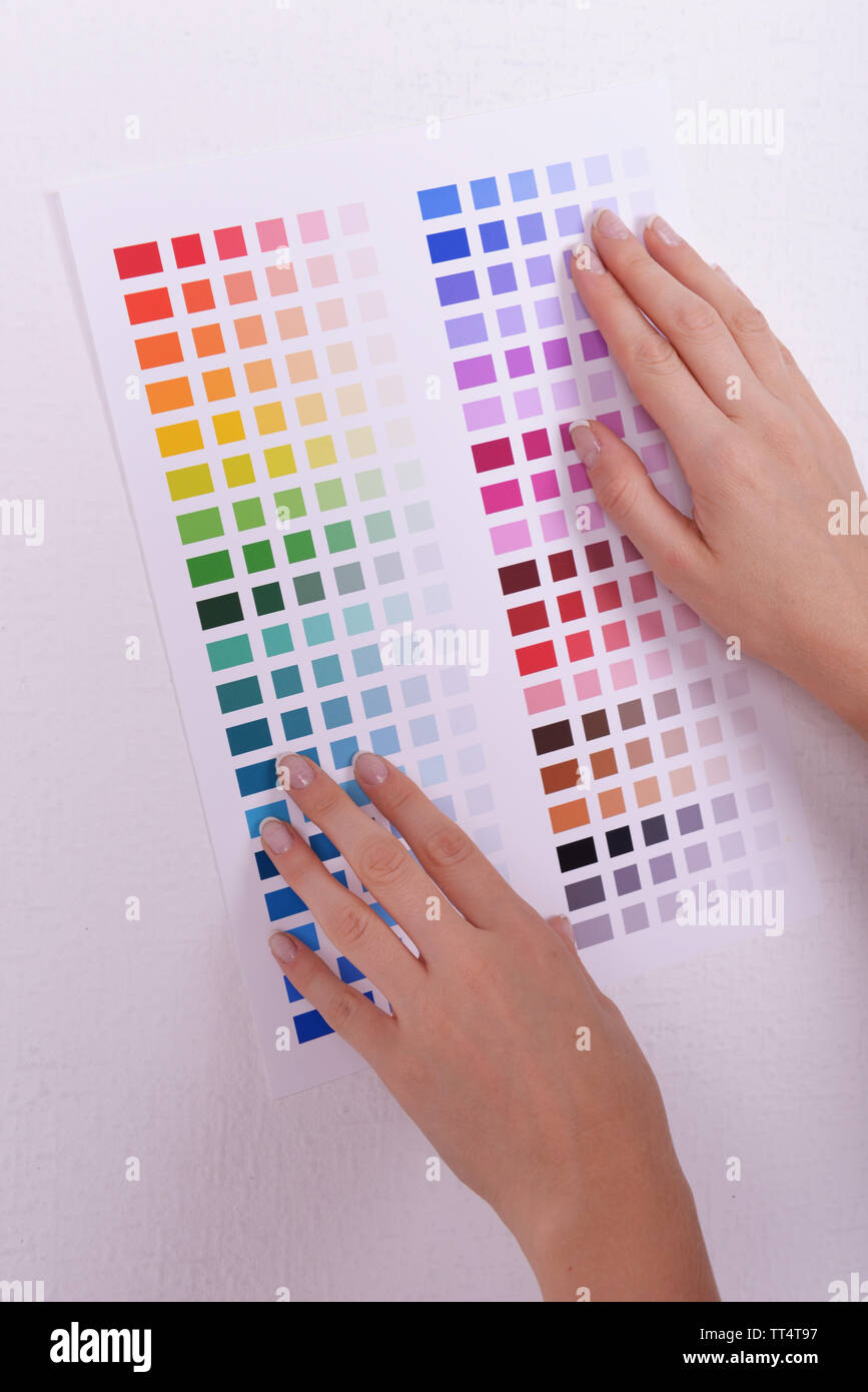 Woman choosing color for wall from swatches in room Stock Photo - Alamy