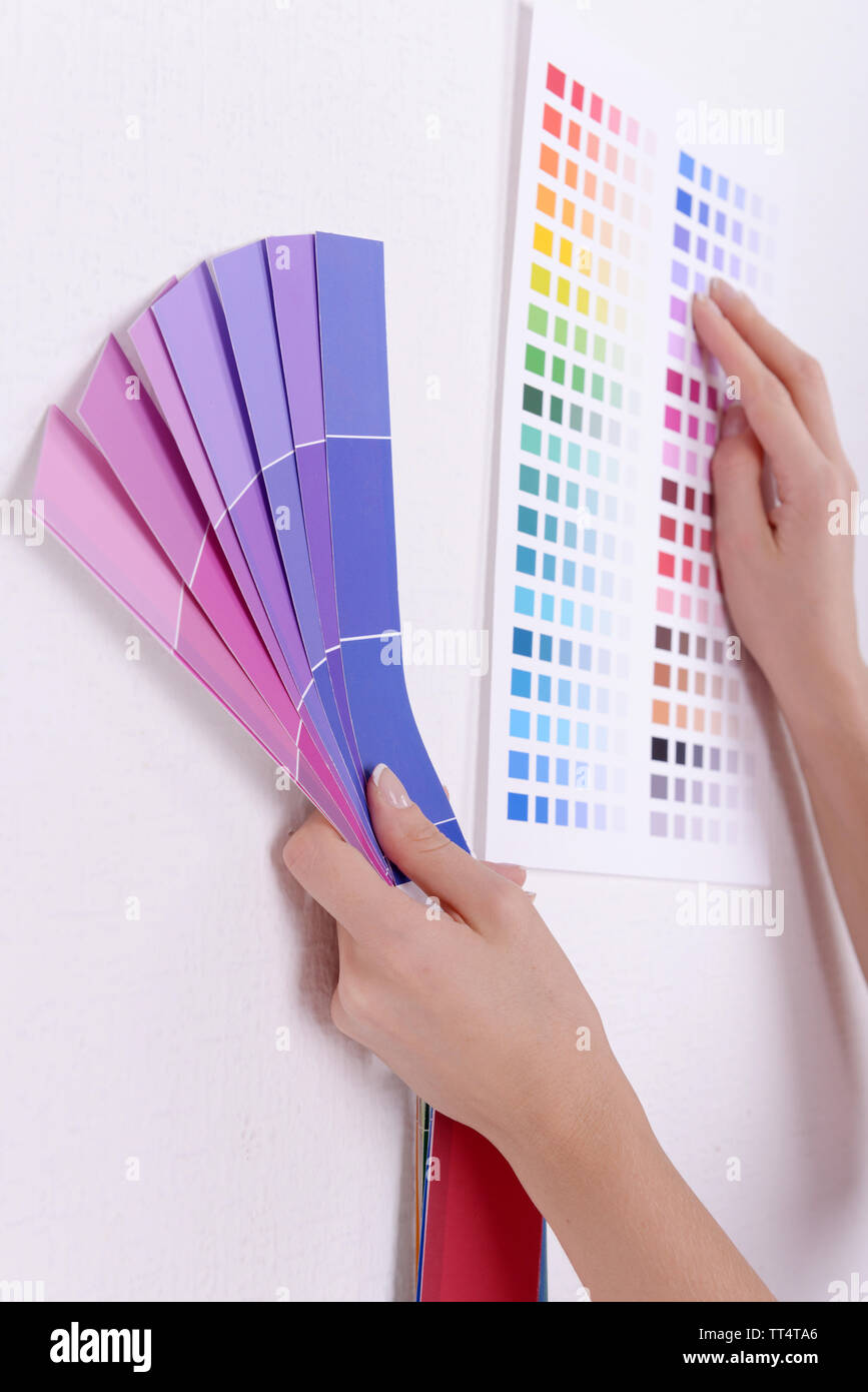 Woman choosing color for wall from swatches in room Stock Photo - Alamy
