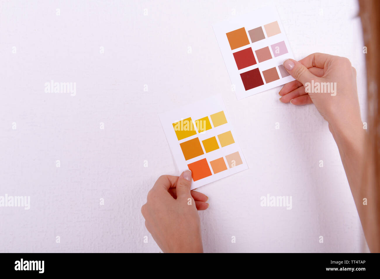Woman choosing color for wall from swatches in room Stock Photo - Alamy