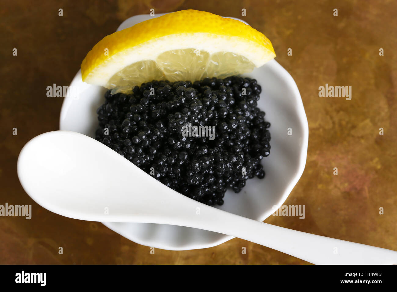 Black caviar and slice of lemon on plate on metal tray background Stock ...