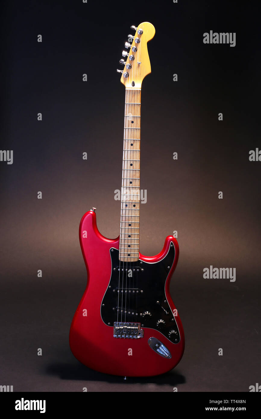 Red guitar on dark background Stock Photo - Alamy