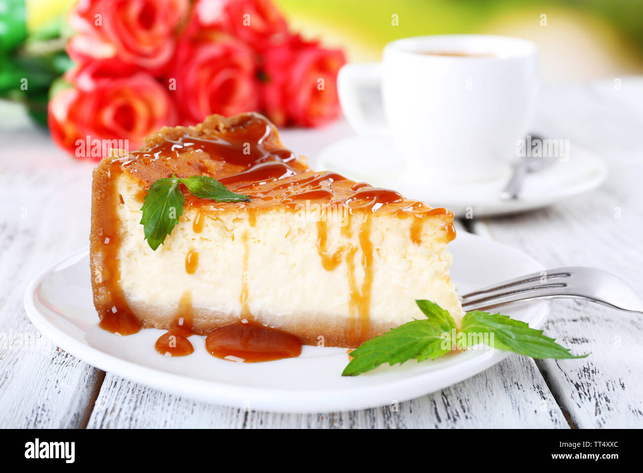 Cheese cake in plate and tuft of roses on table on nature background ...