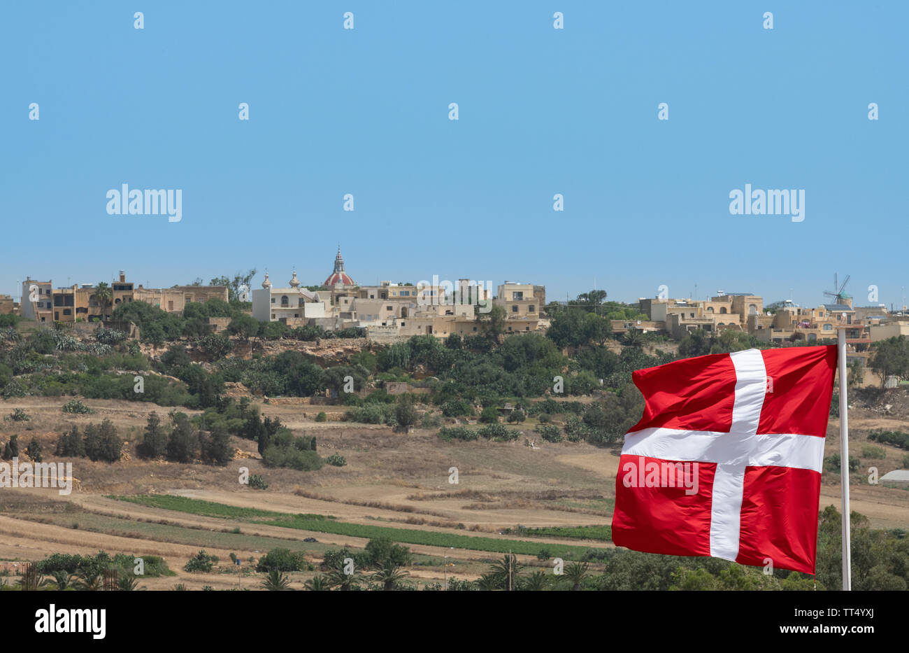 Flag of the Order of Saint John flying over Gozo countryside Stock ...