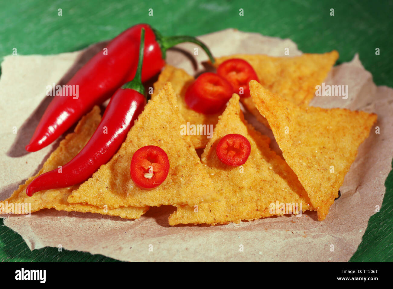 Tasty nachos and chili pepper on paper, on wooden background Stock ...