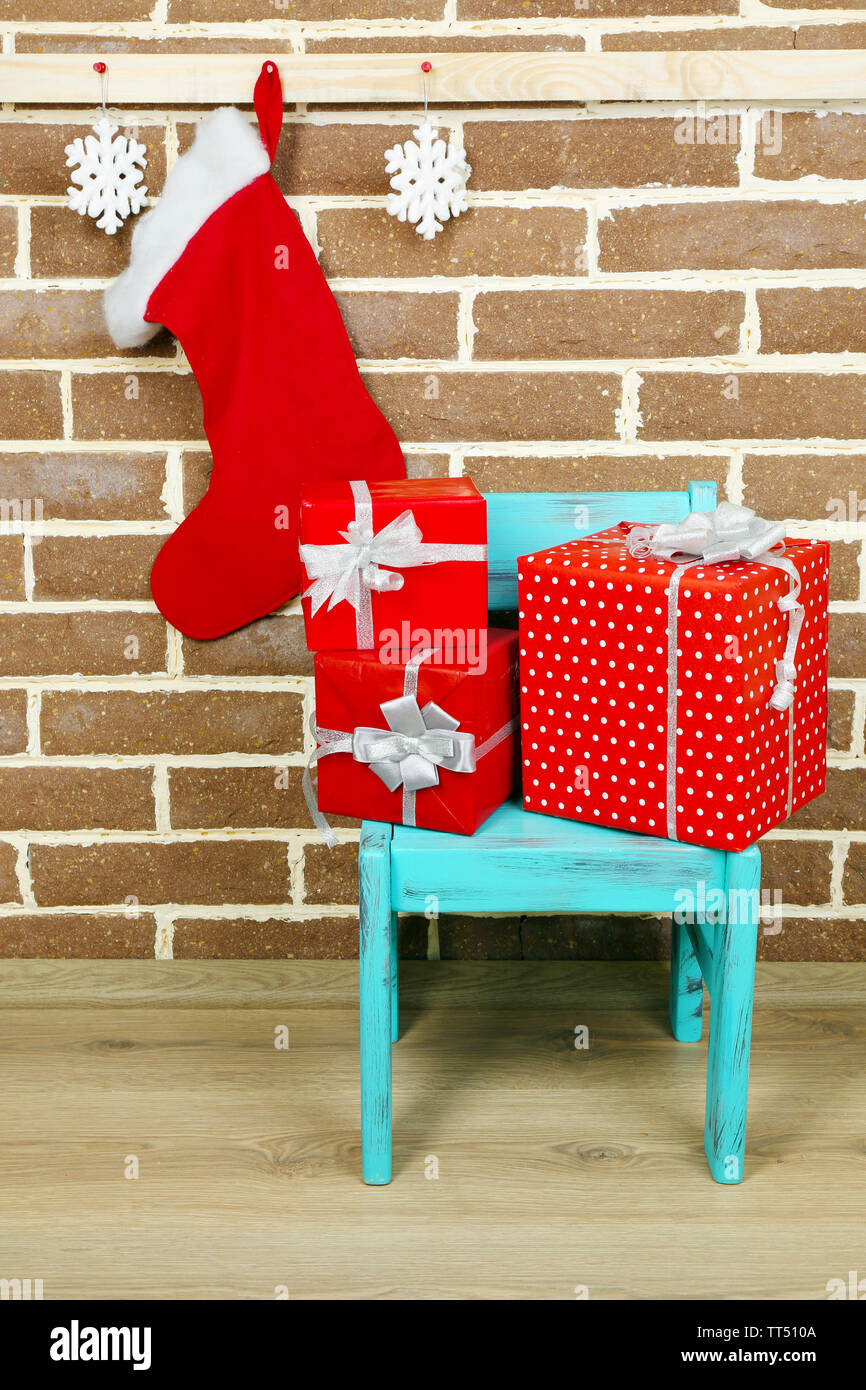 Christmas presents on chair on brown brick wall background Stock Photo ...