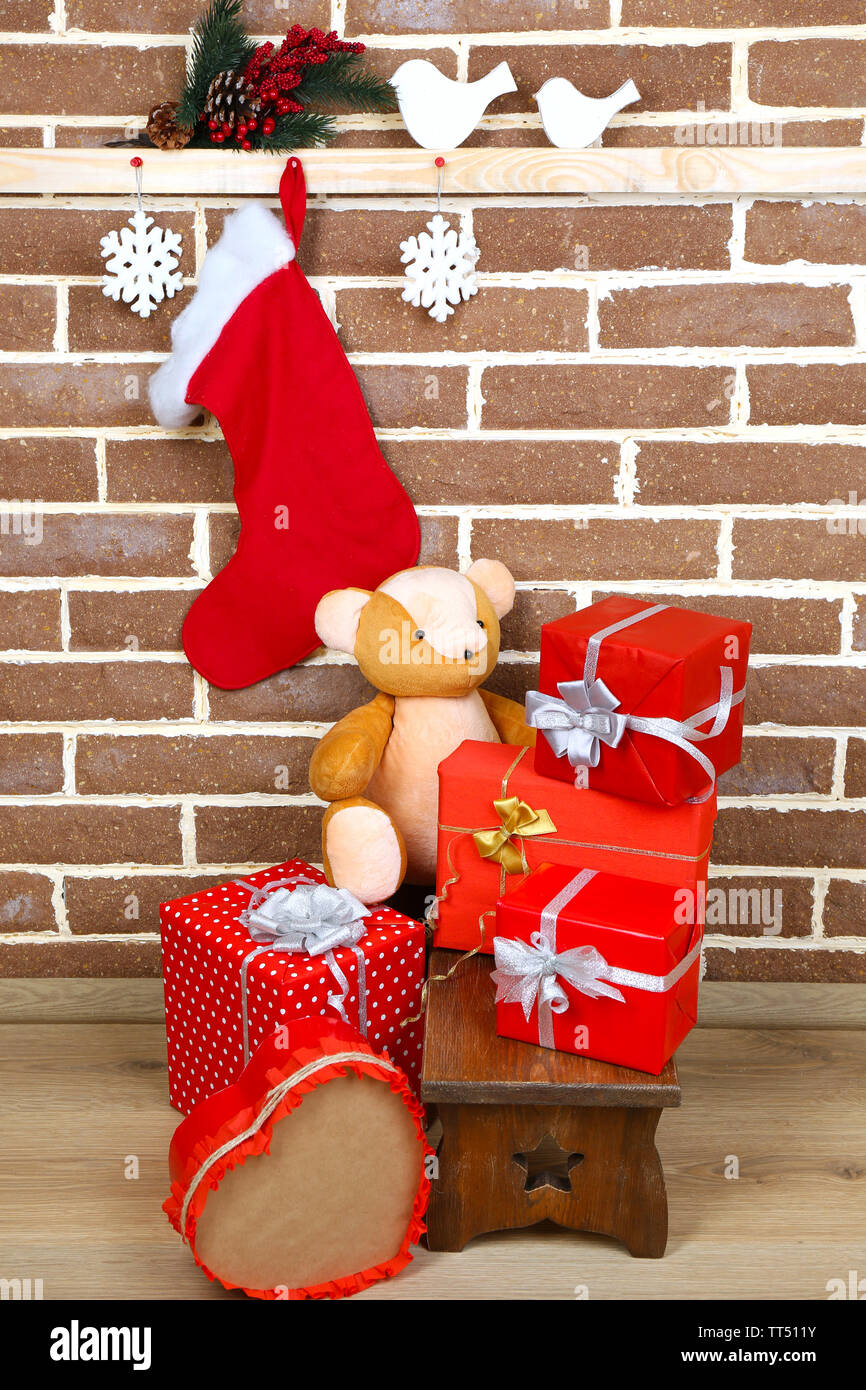 Christmas presents on stool on brown brick wall background Stock Photo ...