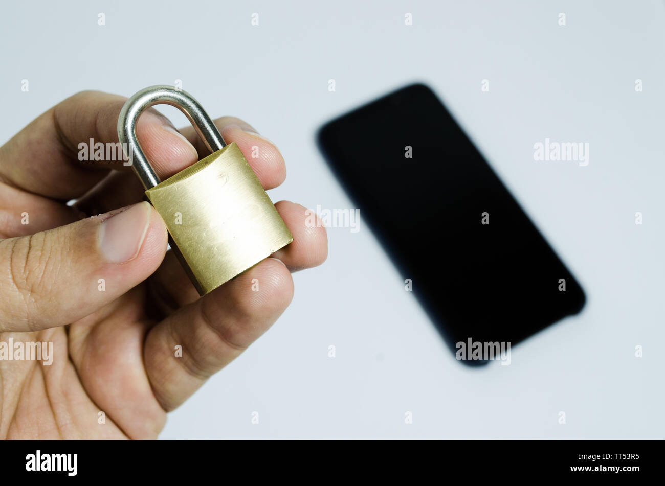 Conceptual photo of security on mobile phones. Hand holding a closed ...