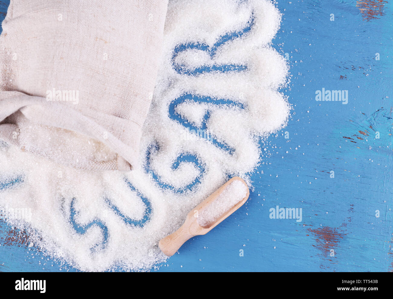 Inscription sugar made of white granulated sugar on color wooden ...