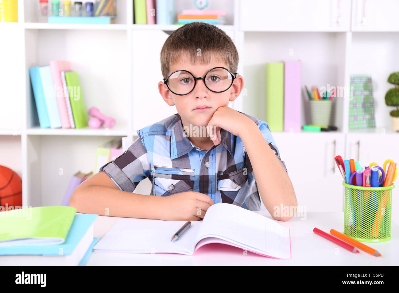 Schoolboy sitting at table in classroom Stock Photo - Alamy