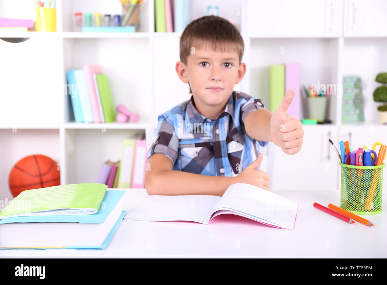 Schoolboy sitting at table in classroom Stock Photo - Alamy