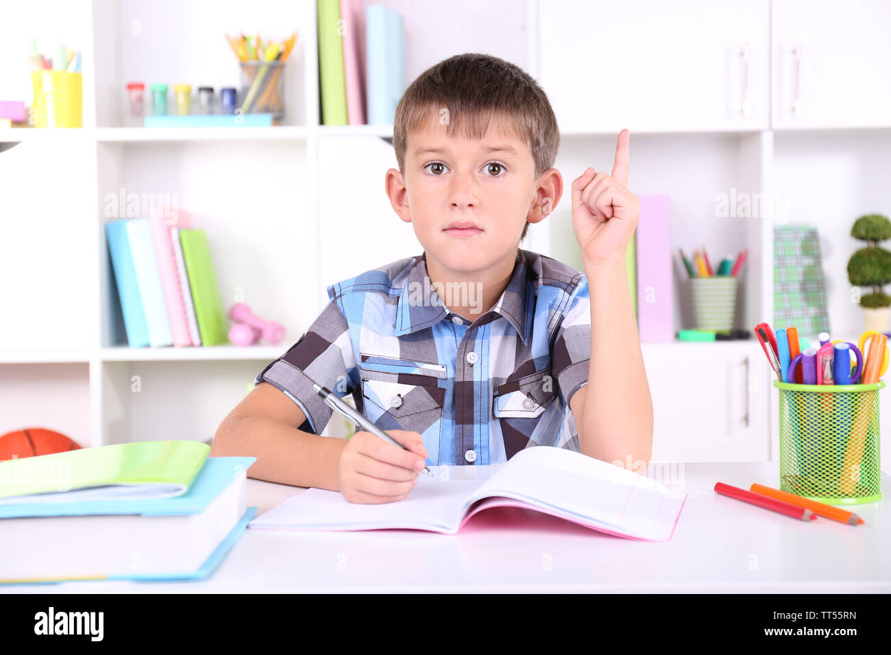 Schoolboy sitting at table in classroom Stock Photo - Alamy