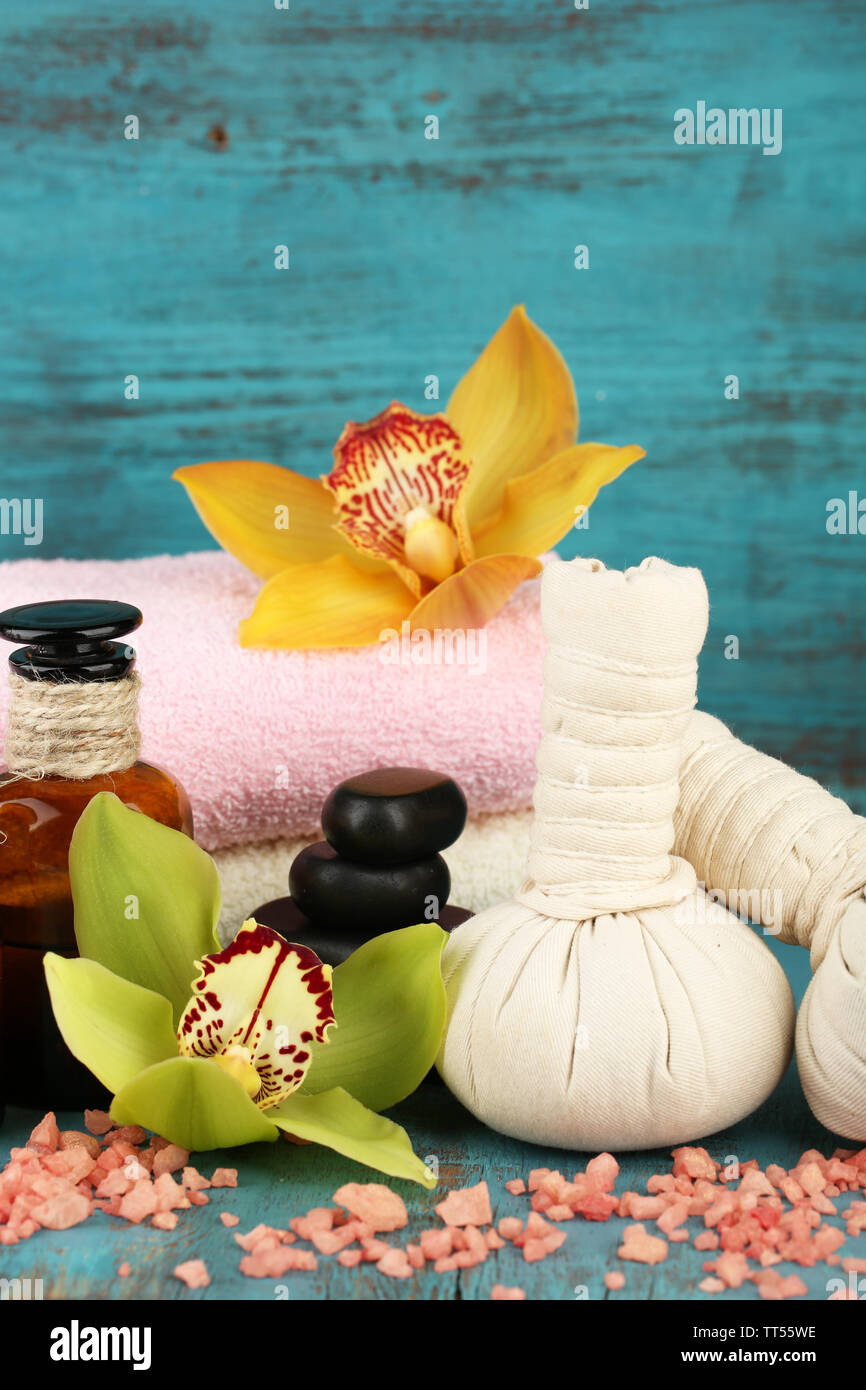 Colorful tropical orchid flowers and spa set on color wooden background ...