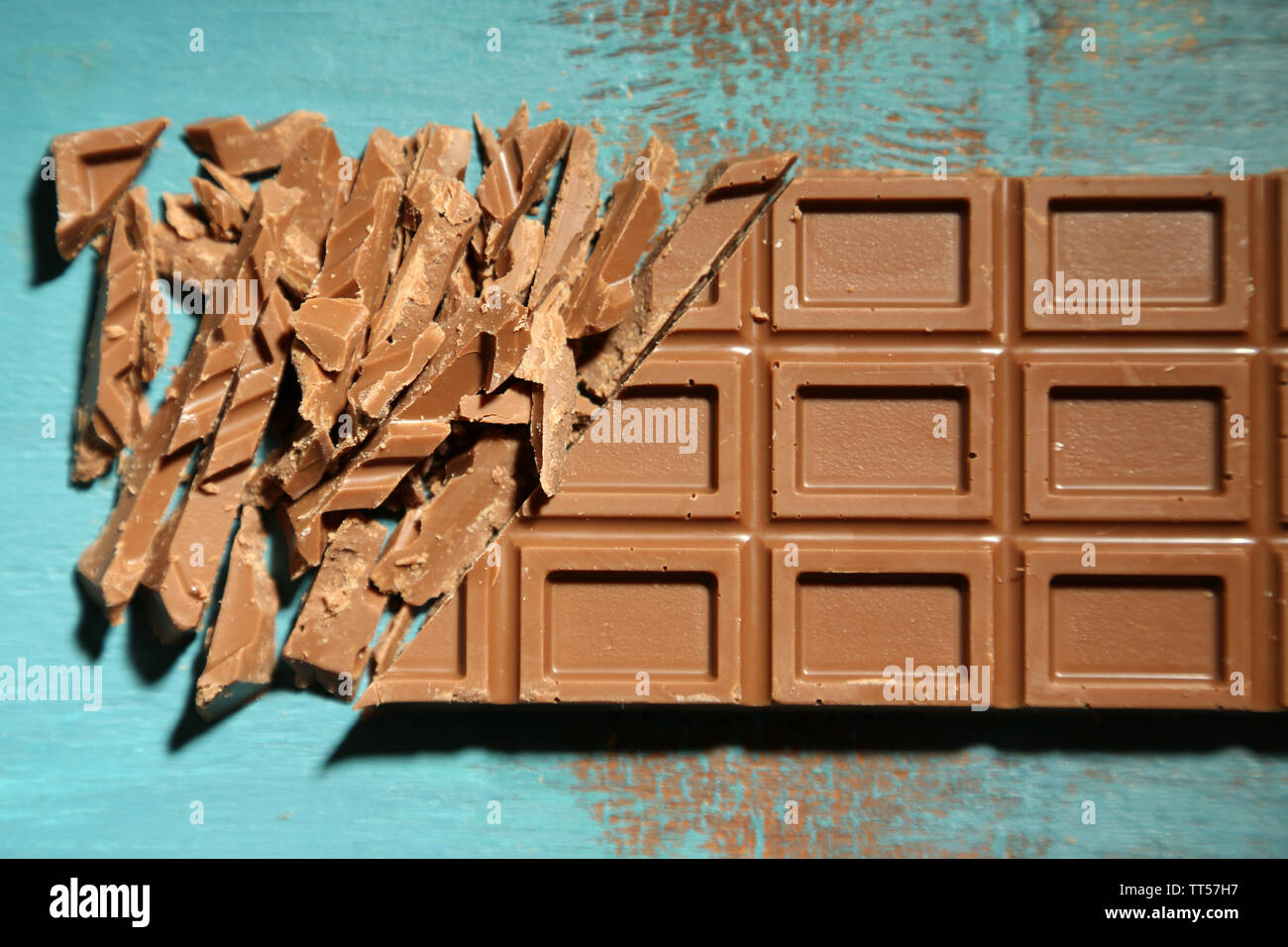 Milk chocolate bar on color wooden background Stock Photo - Alamy