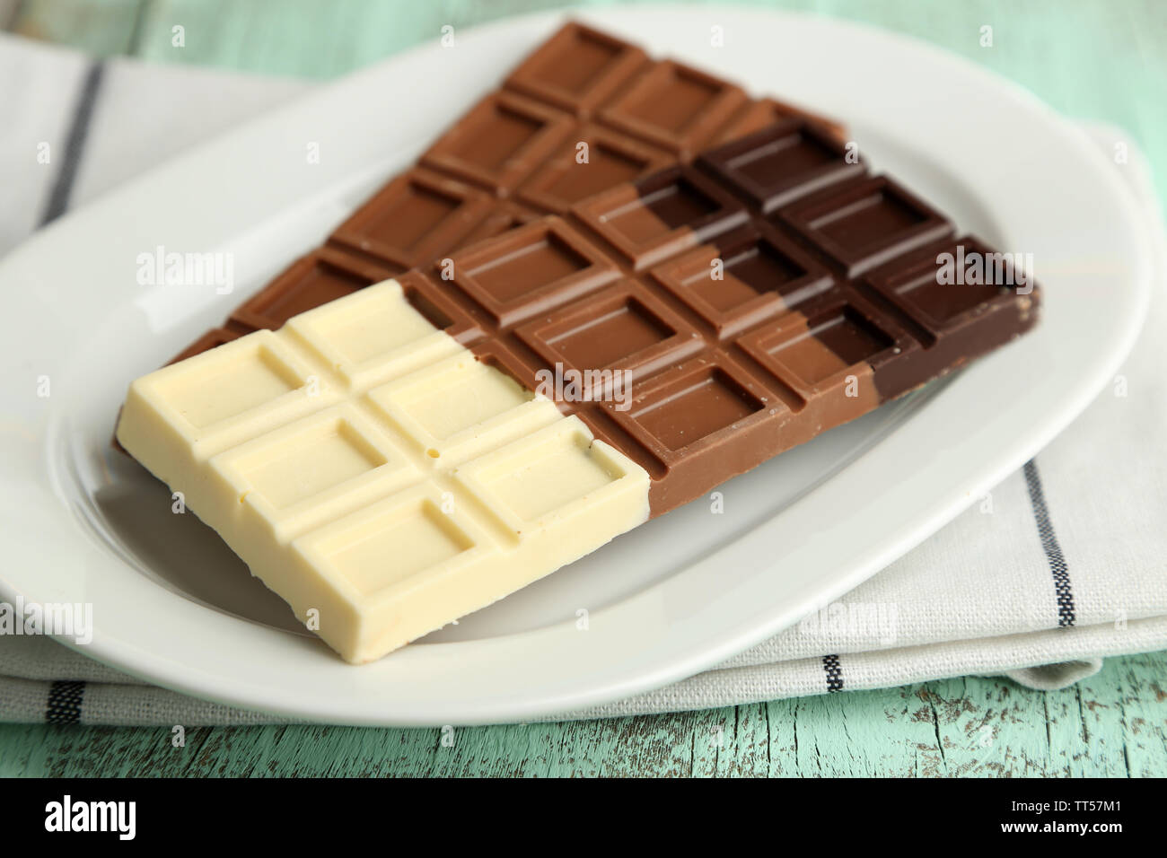 Milk chocolate bar on color wooden background Stock Photo - Alamy