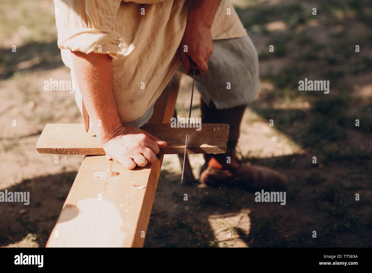 Carpenter sawing board with a hacksaw Stock Photo - Alamy