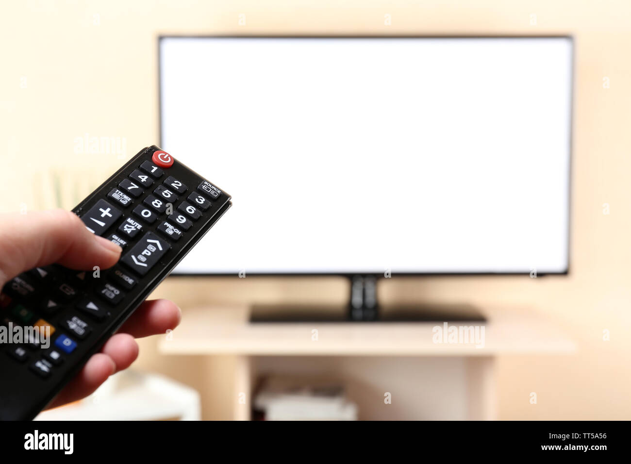 Watching TV and using remote controller Stock Photo - Alamy