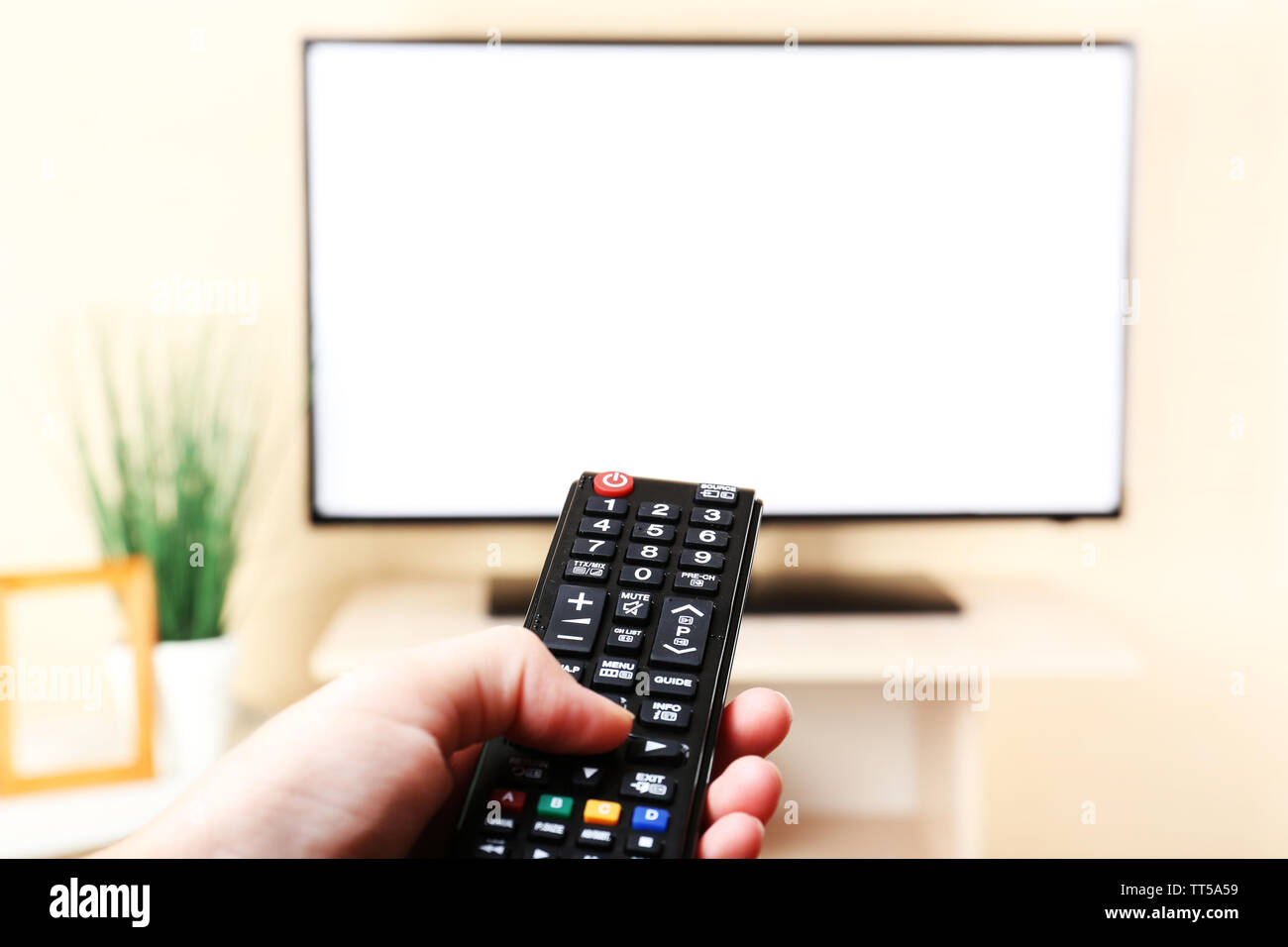 Watching TV and using remote controller Stock Photo - Alamy