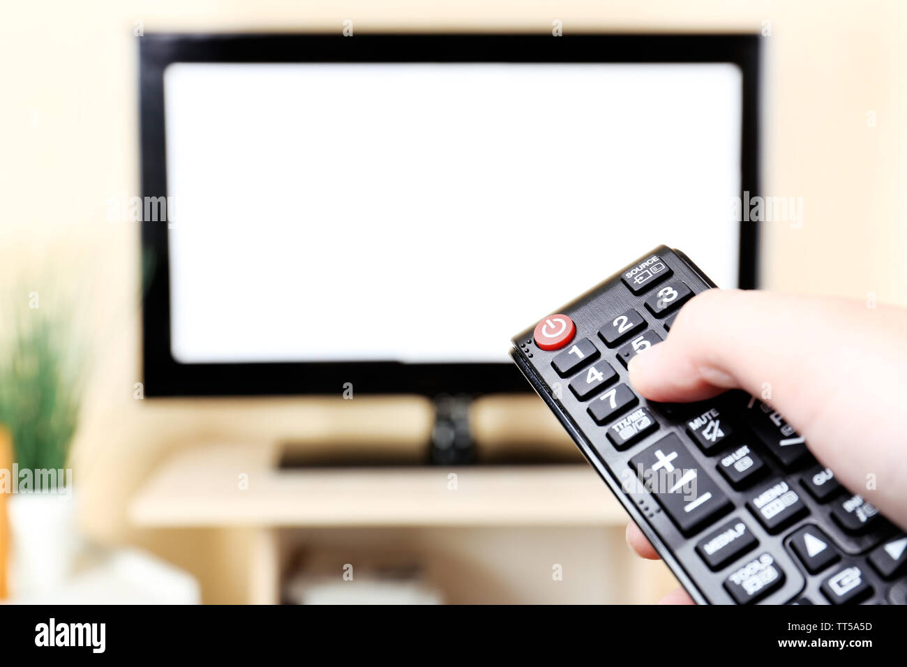 Watching TV and using remote controller Stock Photo - Alamy