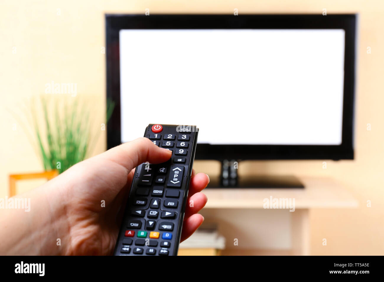Watching TV and using remote controller Stock Photo - Alamy