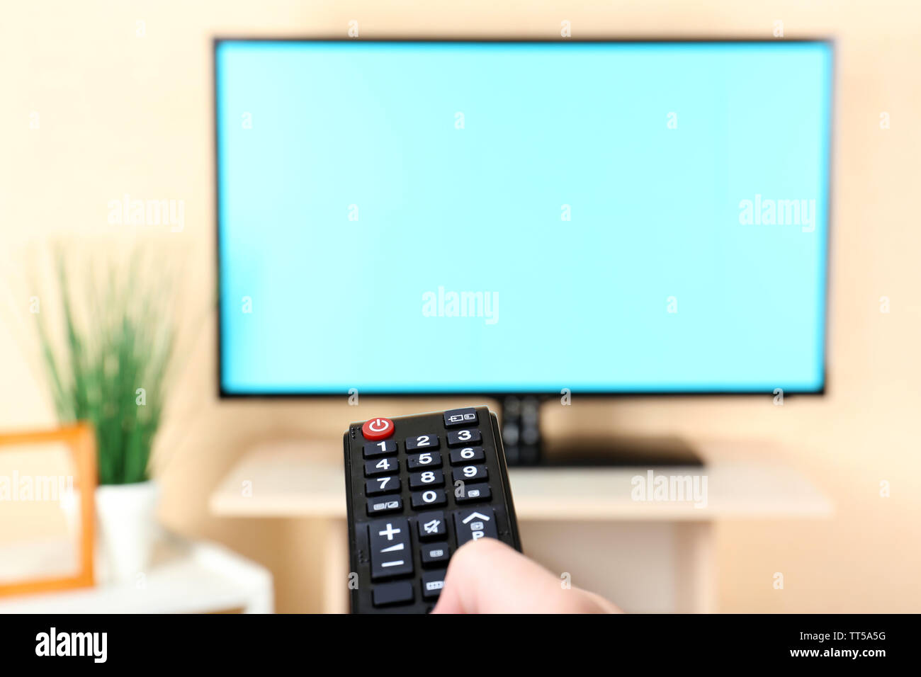 Watching TV and using remote controller Stock Photo - Alamy