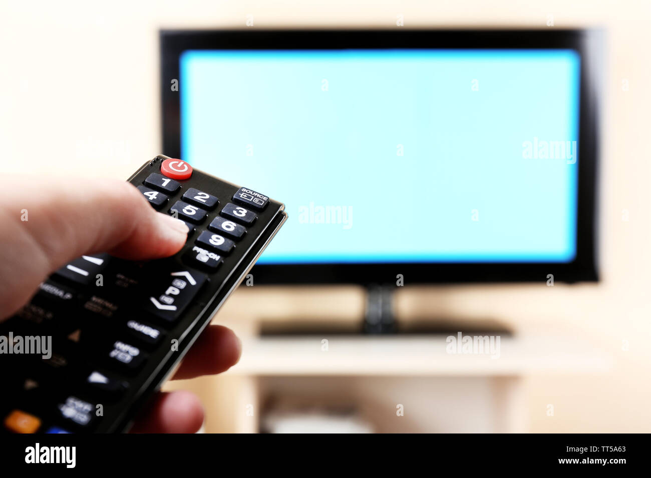Watching TV and using remote controller Stock Photo - Alamy