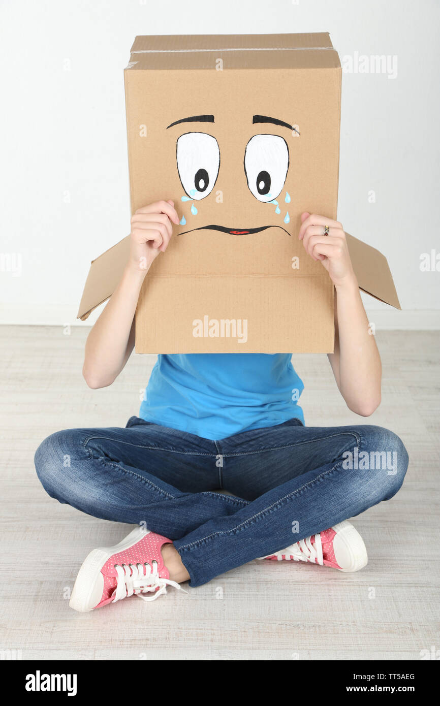 Woman with cardboard box on her head with sad face, near wall Stock ...